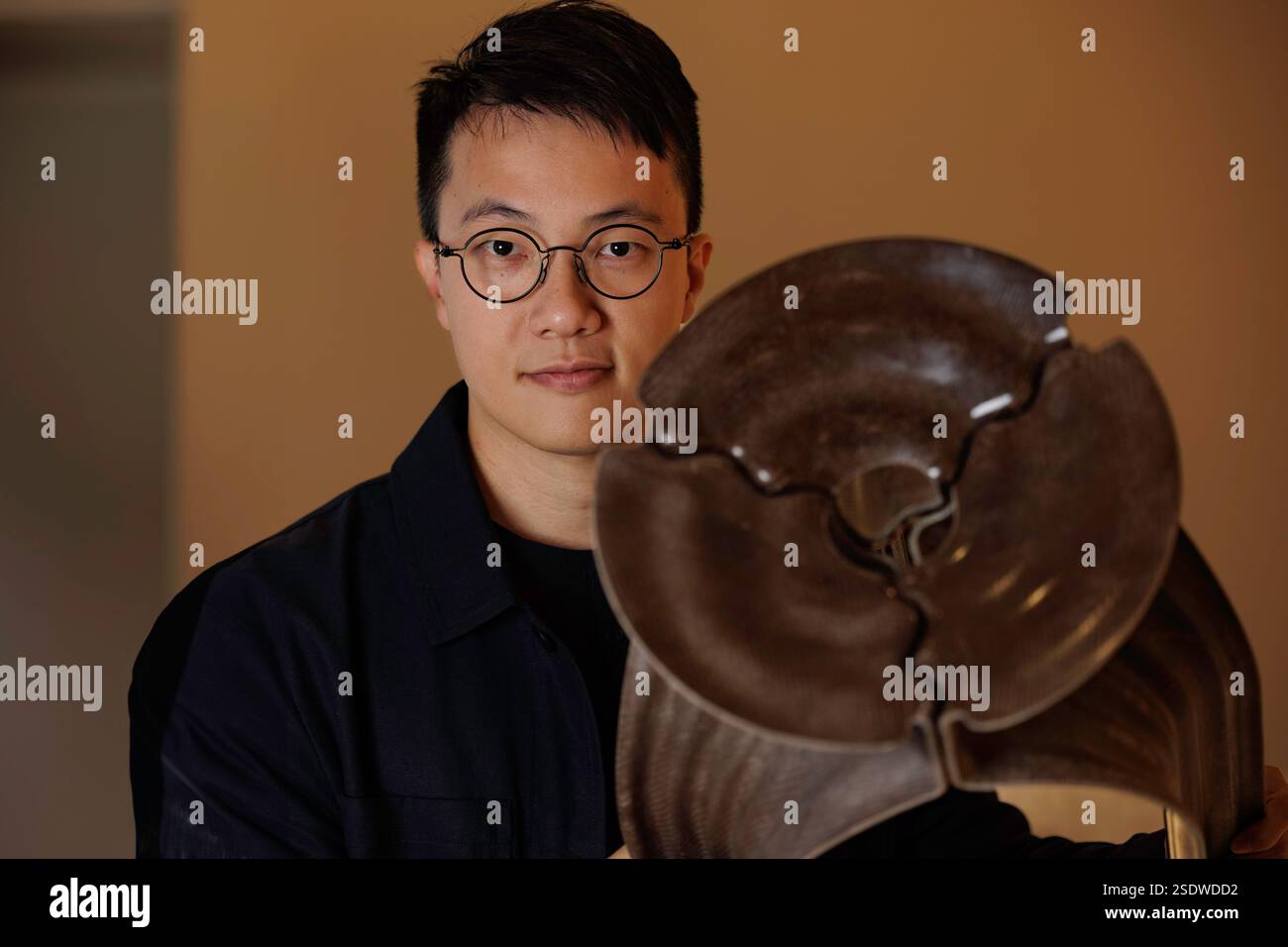 Dennis Cheung tient son tabouret Triplex lors de la cérémonie d'ouverture de la collection ...