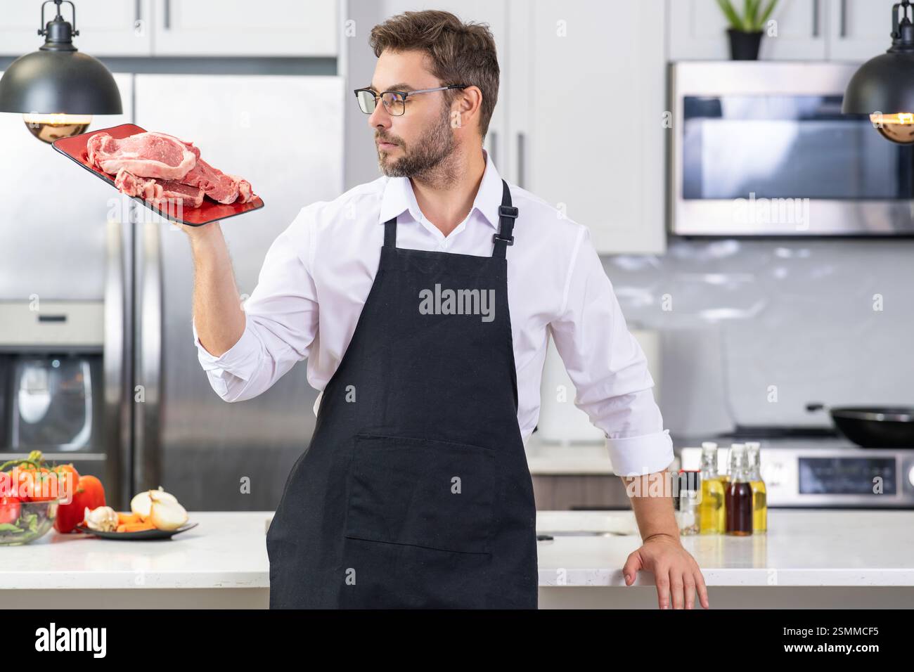 Cuisinier homme chef tenir la viande de bœuf. Concept de steak de bœuf ...