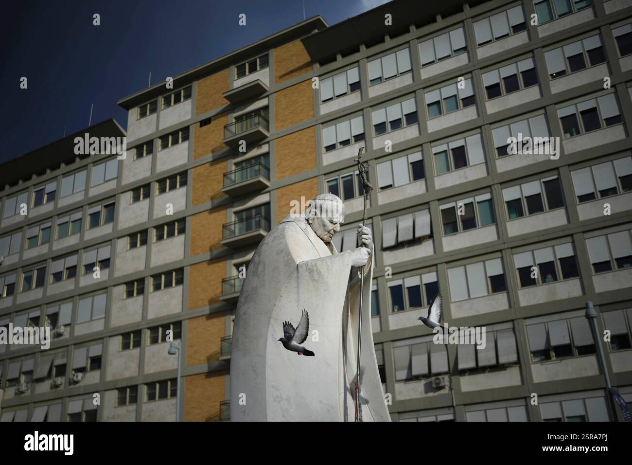 A marble statue of late Pope John Paul II is backdropped by the ...