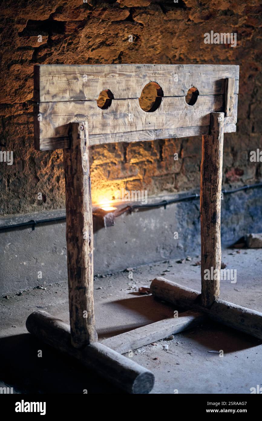 Pilori dans un donjon de musée faiblement éclairé, des ombres ...