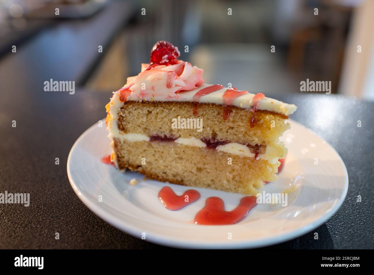 Une tranche de gâteau bakewell avec une garniture de framboise sur une ...