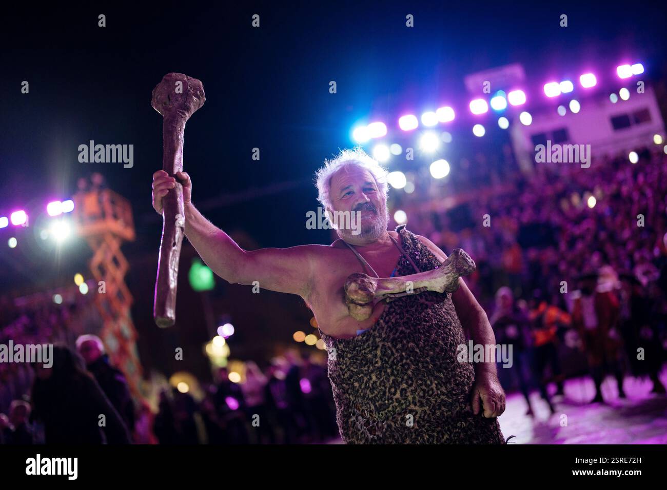 A carnival-goer dressed as a prehistoric man parades through Place ...