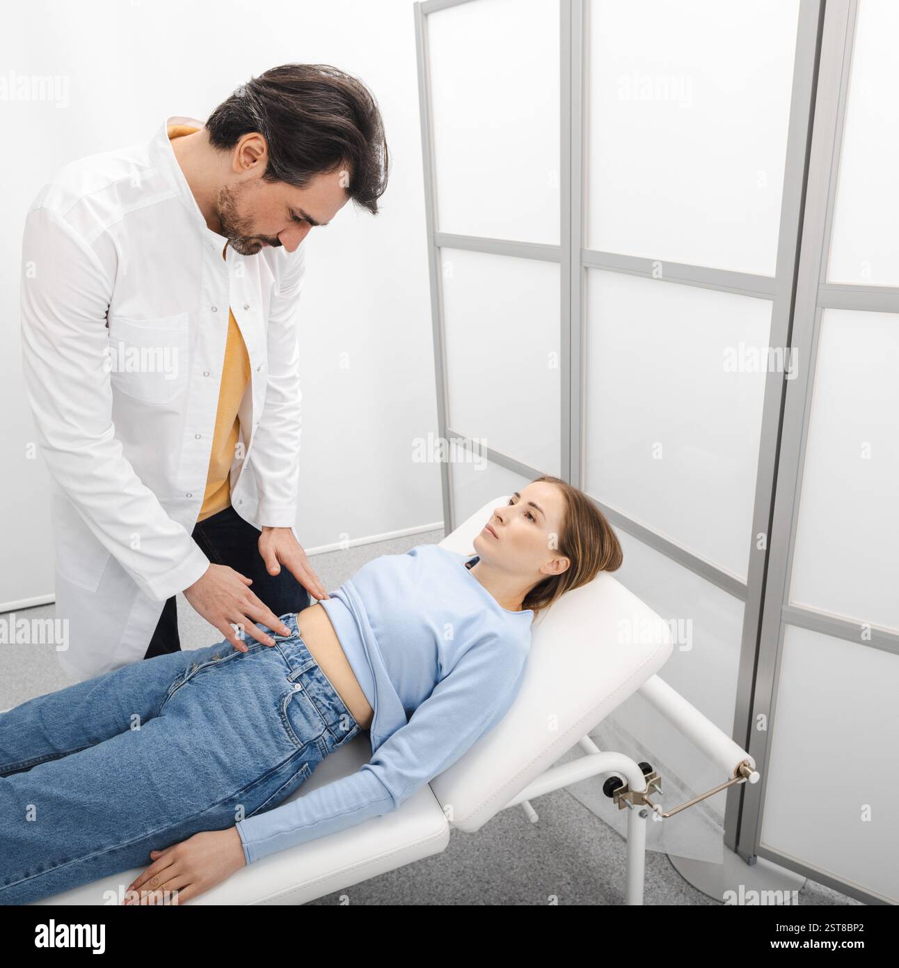 Le médecin palpe l'abdomen du patient de femme et examine le ventre à ...