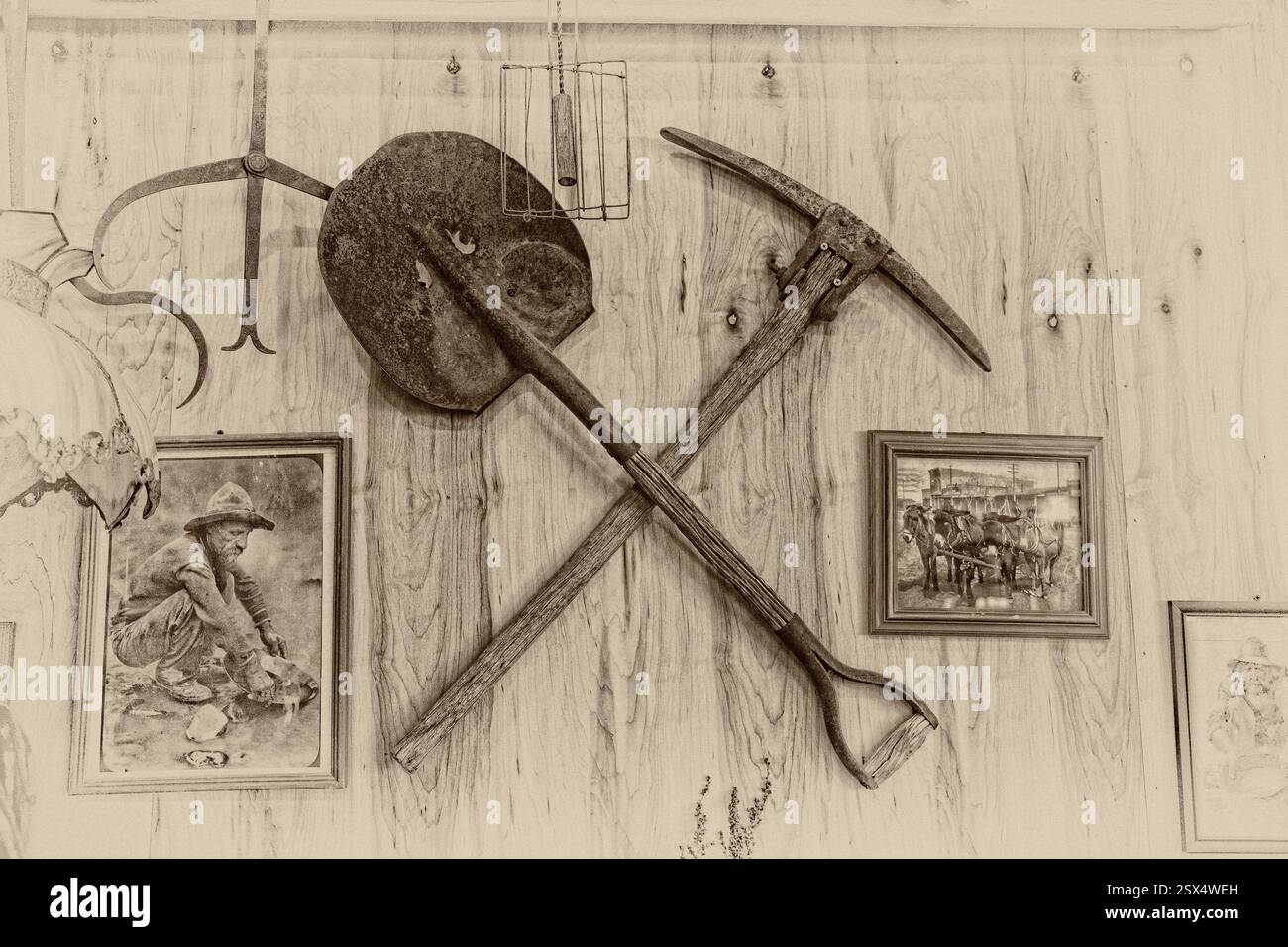 Photo d'un pic et une pelle accrochée à un mur. Il y a deux images sur ...