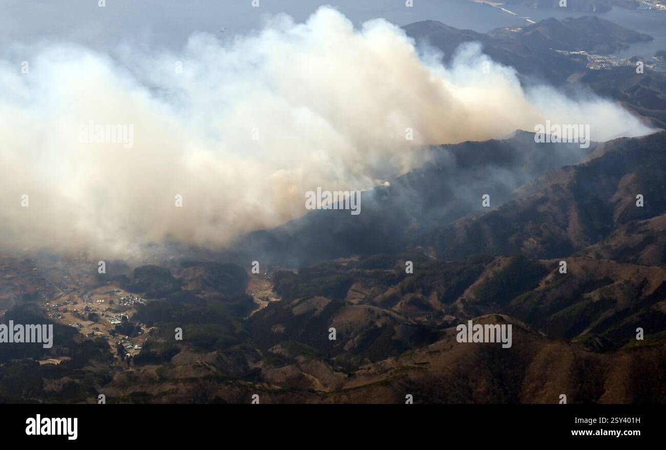 An aerial photo shows a forest fire, continues to spread in Ofunato ...