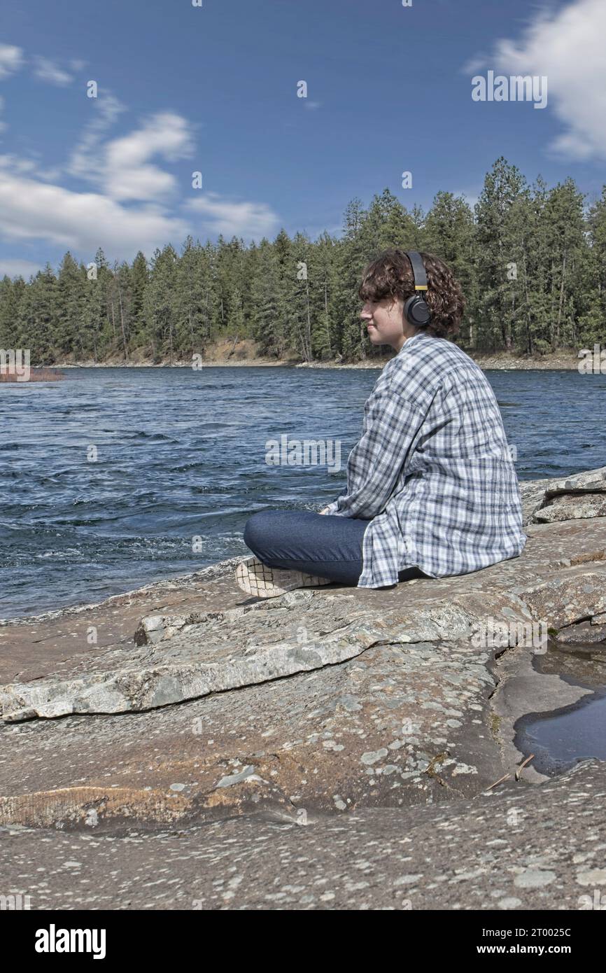Une femme est assise sur un rocher Banque de photographies et d’images à haute résolution - Alamy