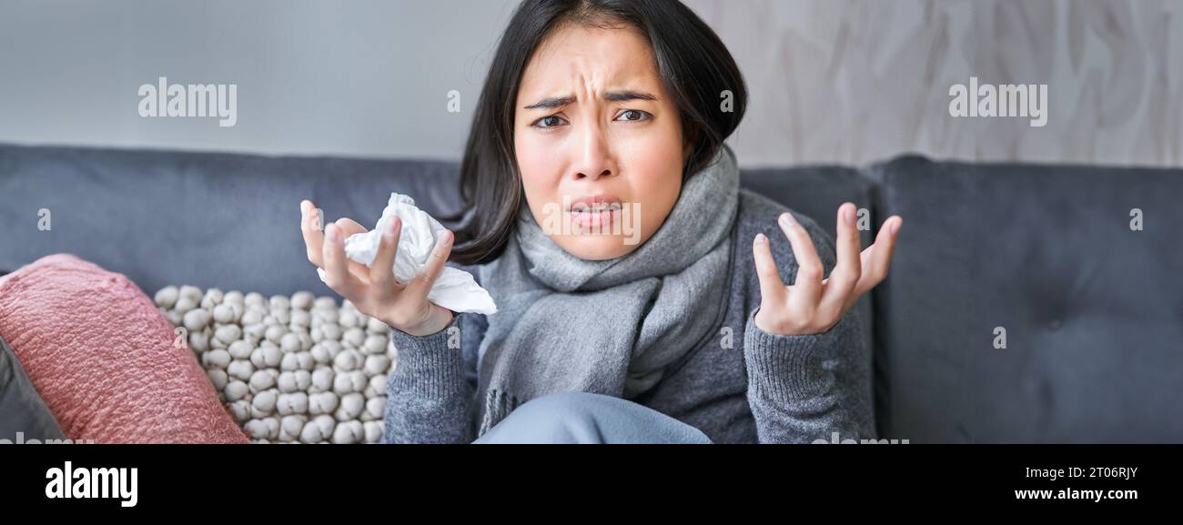 Portrait d'une femme triste se sentant mal, portant des vêtements chauds et une écharpe à sa ...