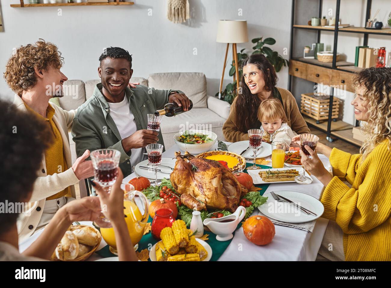 Famille multiculturelle profitant du dîner de Thanksgiving à la table ...