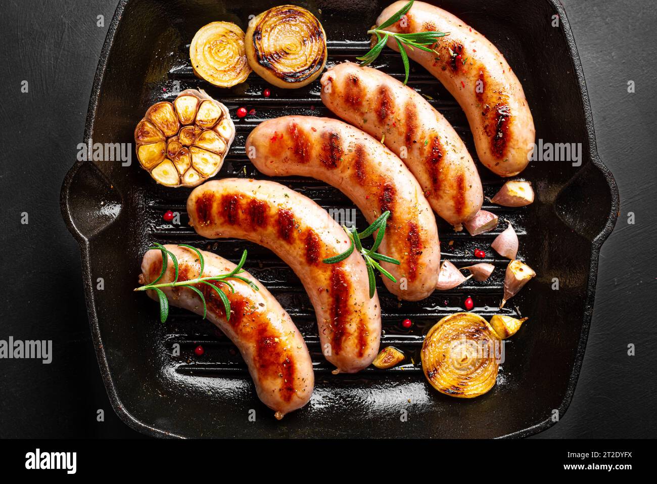 Saucisses grillées avec des légumes et du romarin sur une poêle en ...