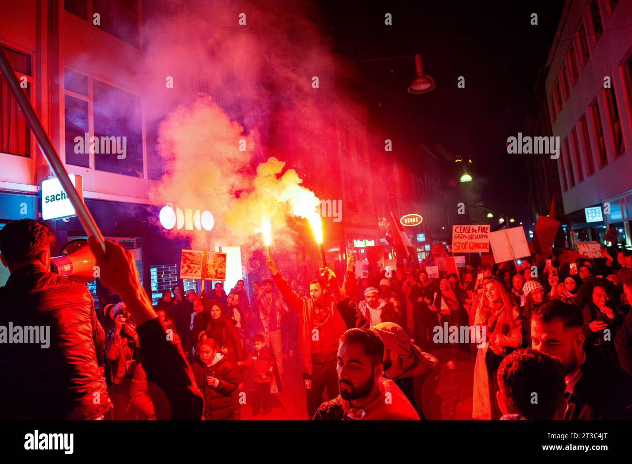 Des manifestants sont vus autour d'un homme tenant une fusée rouge ...