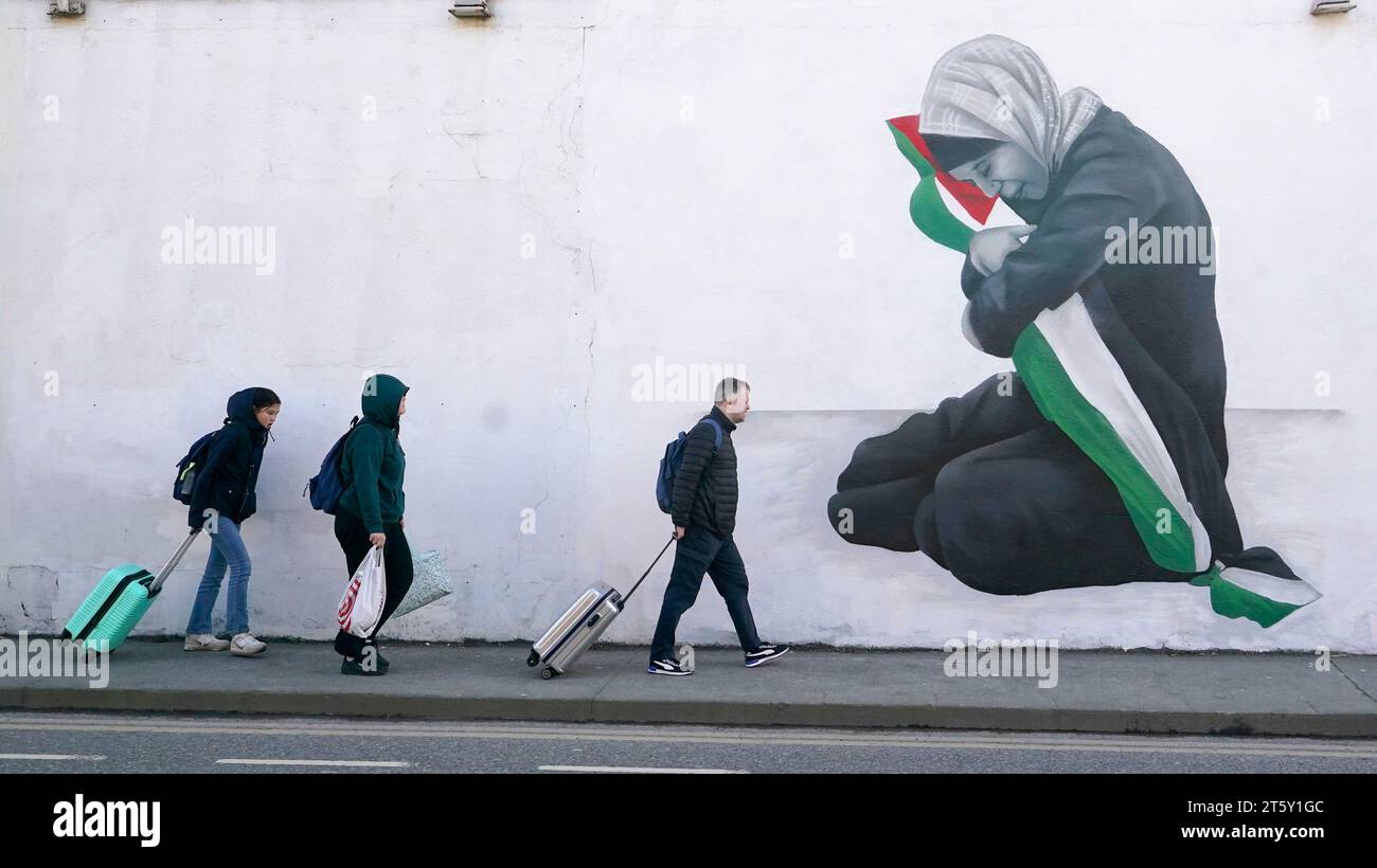 Les gens passent devant une fresque pro-palestinienne de l'artiste Emmalene Blake dans le ...