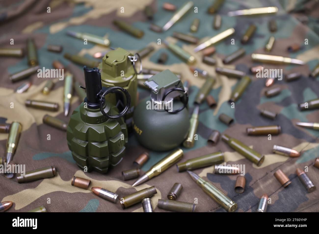 Différents types de munitions et de grenades sur fond de camouflage ...