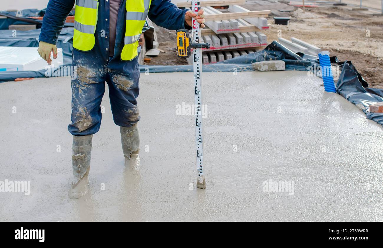Constructeur versant la dalle de sol d'une nouvelle maison avec du ...