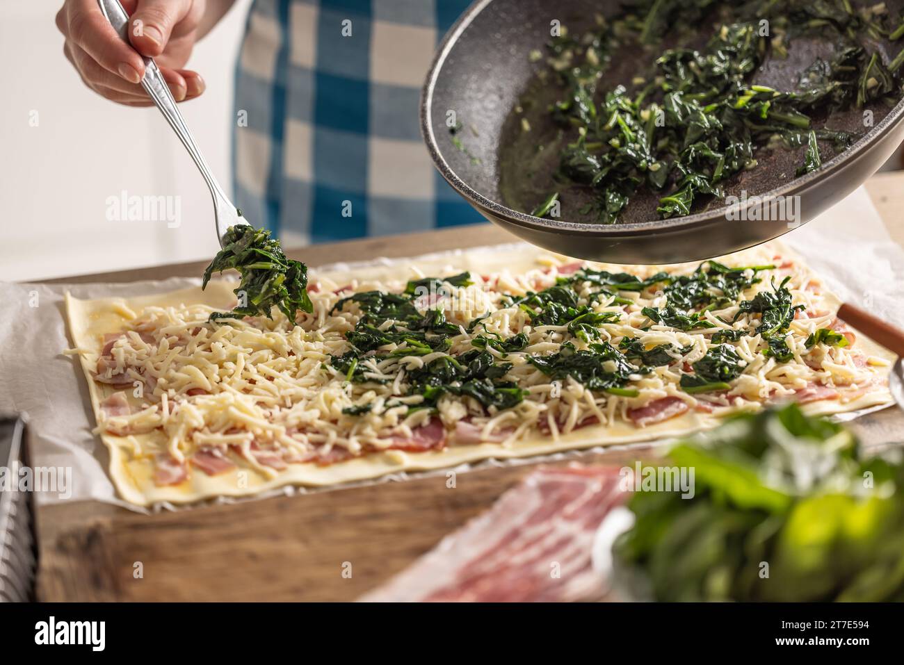Le cuisinier prépare des mini-gâteaux à pizza, met les épinards sur la ...