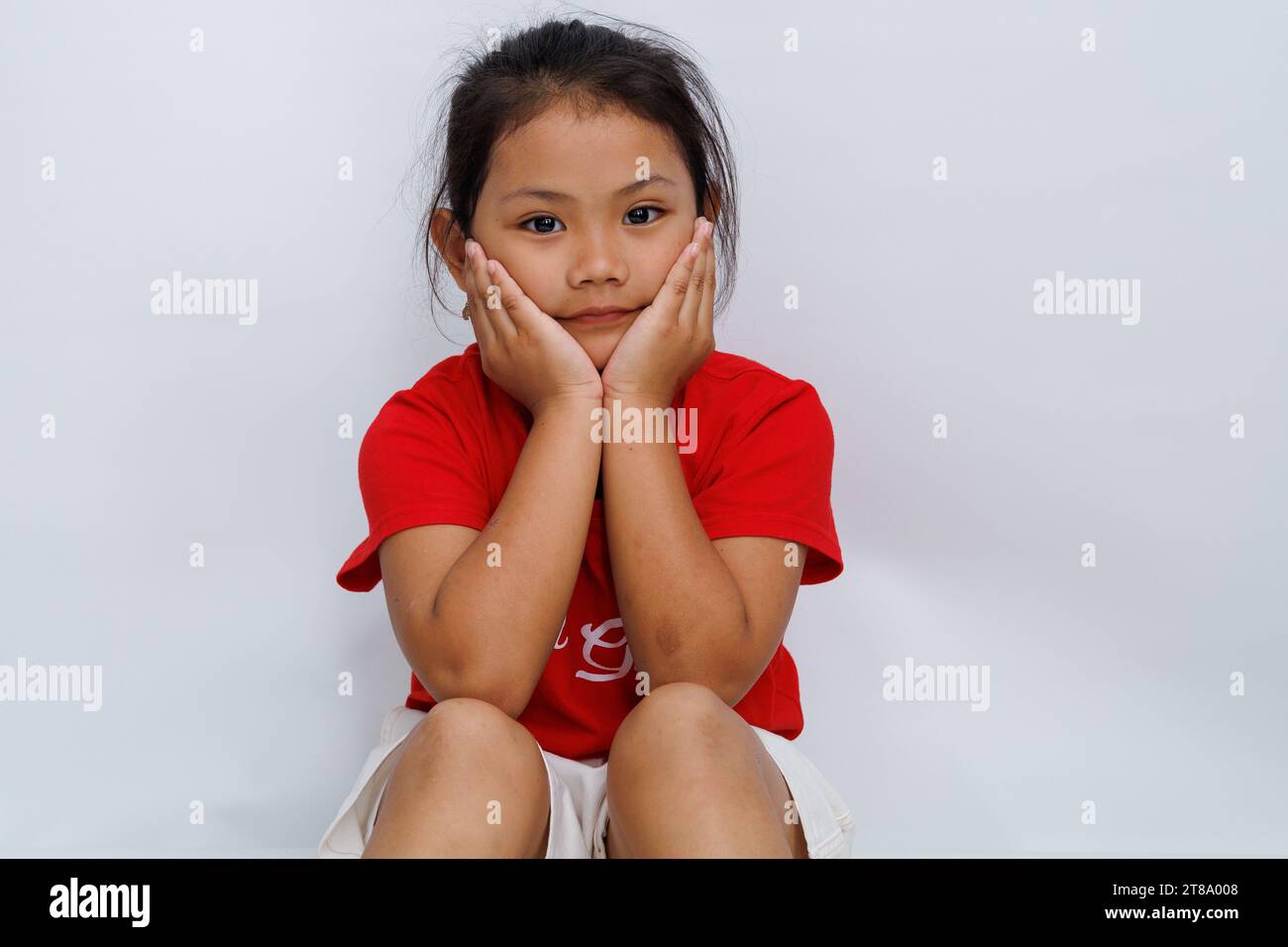 Portrait d'une petite fille asiatique portant un t-shirt rouge avec les ...