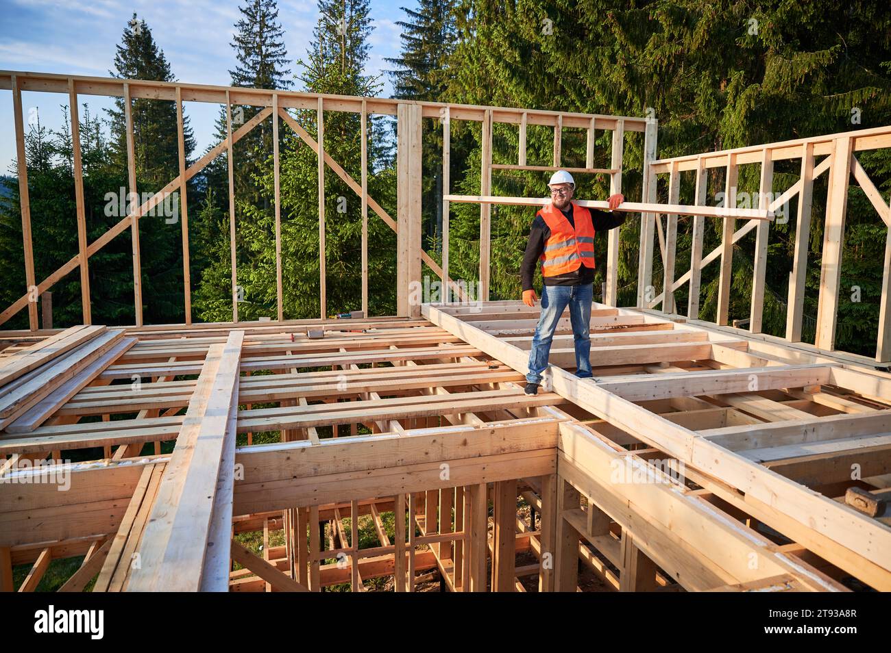 Carpenter construit une maison à ossature en bois près des bois. L ...