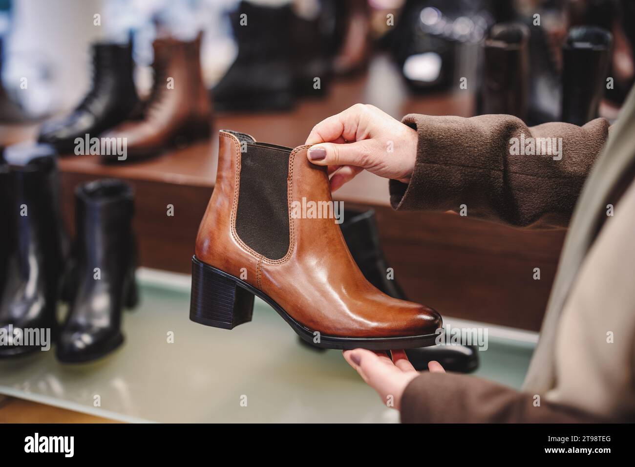 Femme choisissant des chaussures en magasin Banque de photographies et ...