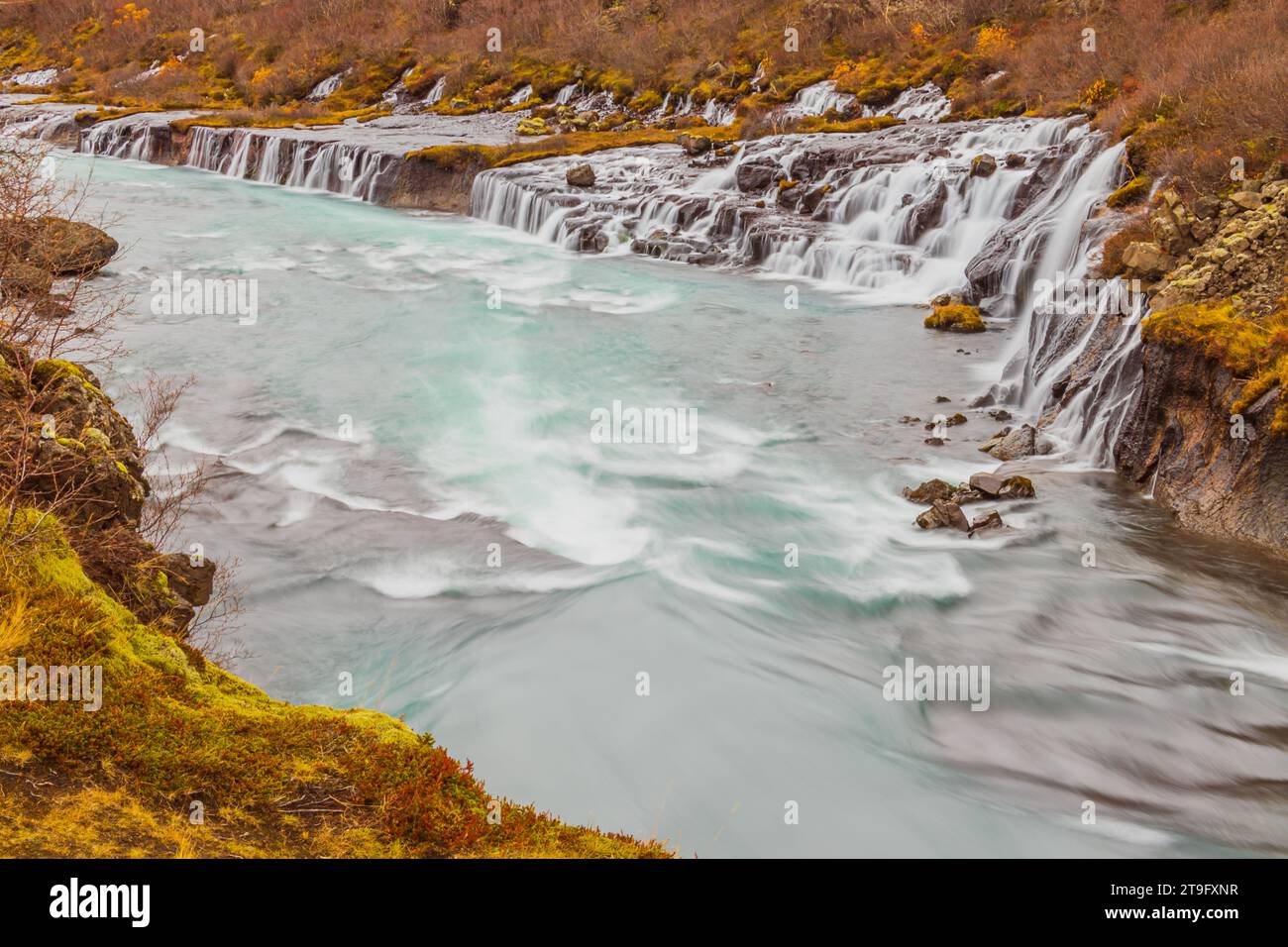 La cascade de Hraunfossar en automne, est une série de cascades formées ...
