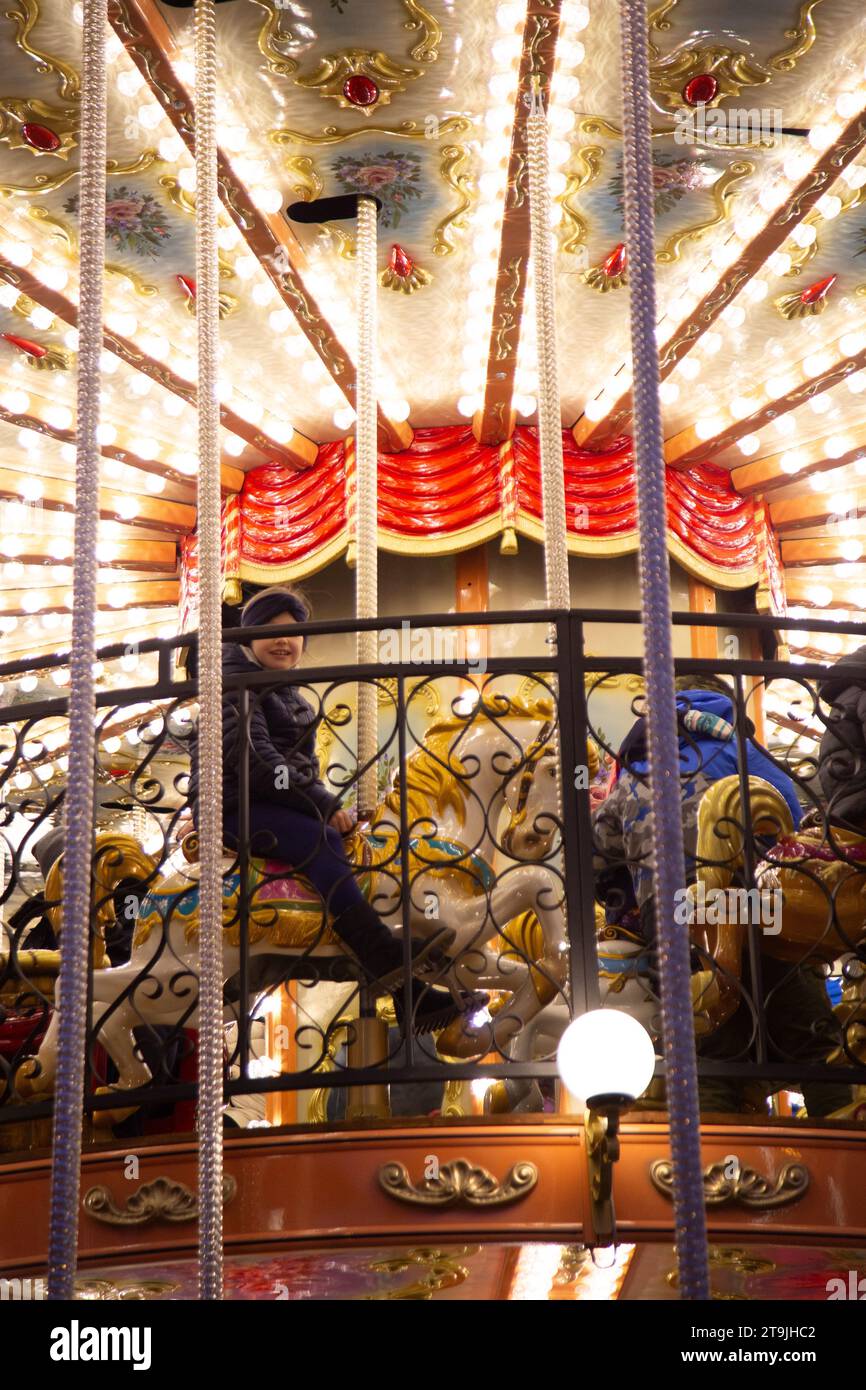 Un gros plan sur un carrousel décoré de belles lumières au marché de ...