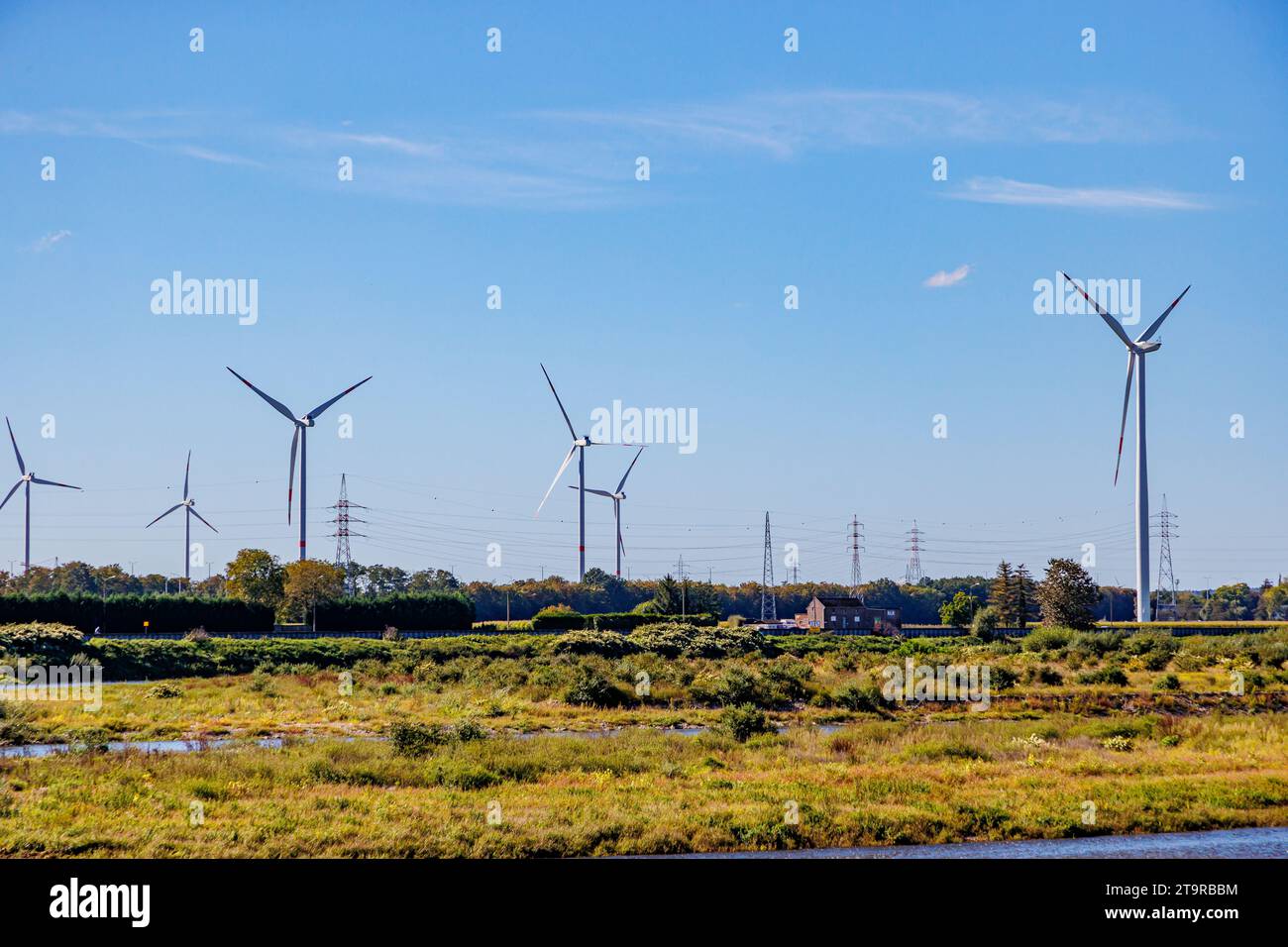 Moulins à vent et pylônes électriques dans la campagne belge avec ciel ...