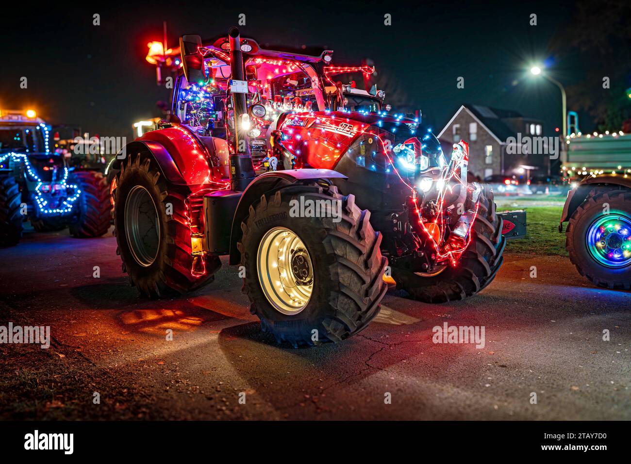 Lichterfahrt - mit glitzernden Lichterketten geschmückter roter Traktor auf einem Sammelplatz ...
