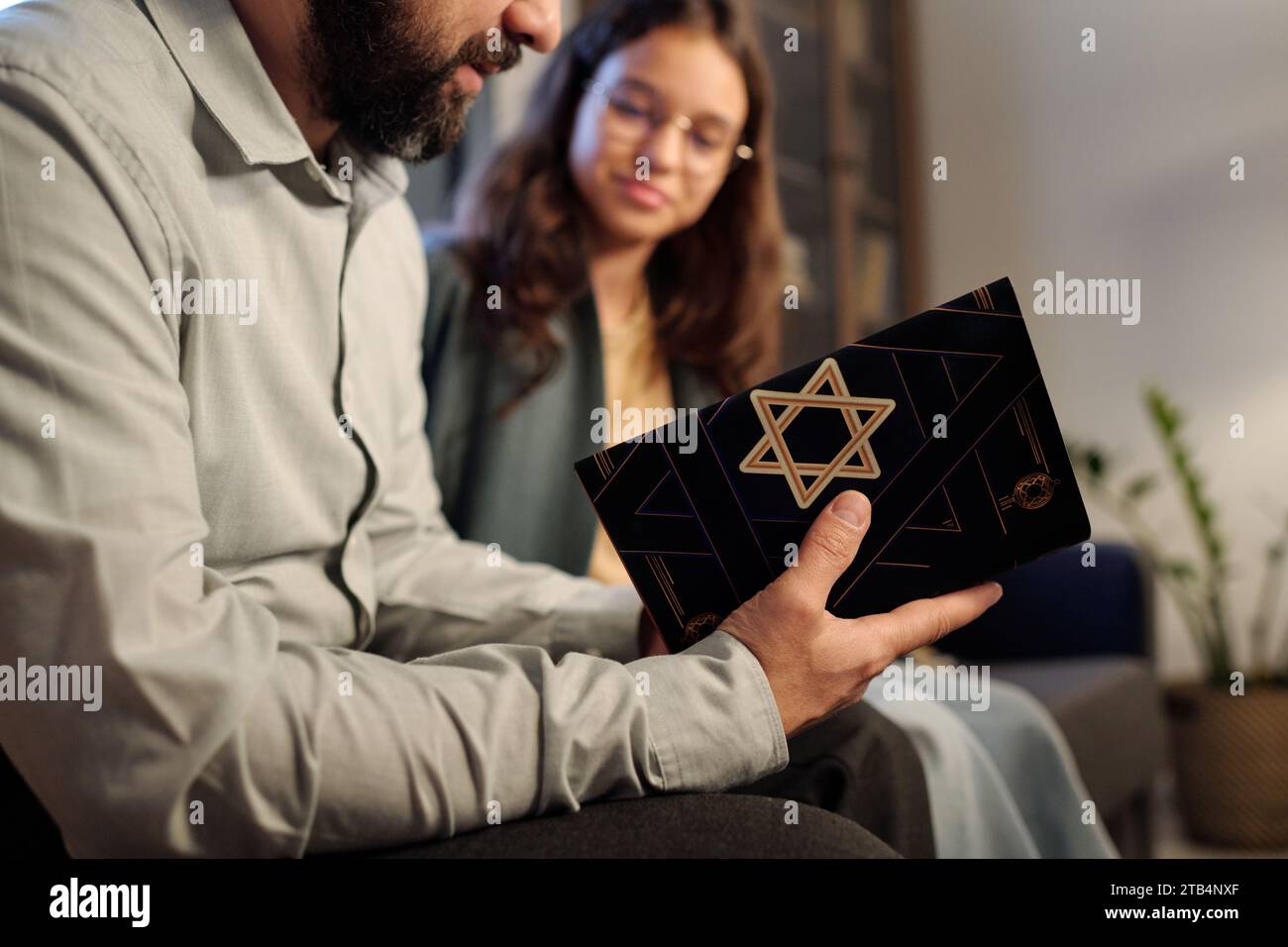 Focus sur la Torah avec l'étoile de David sur la couverture noire dans les mains de l'homme ...