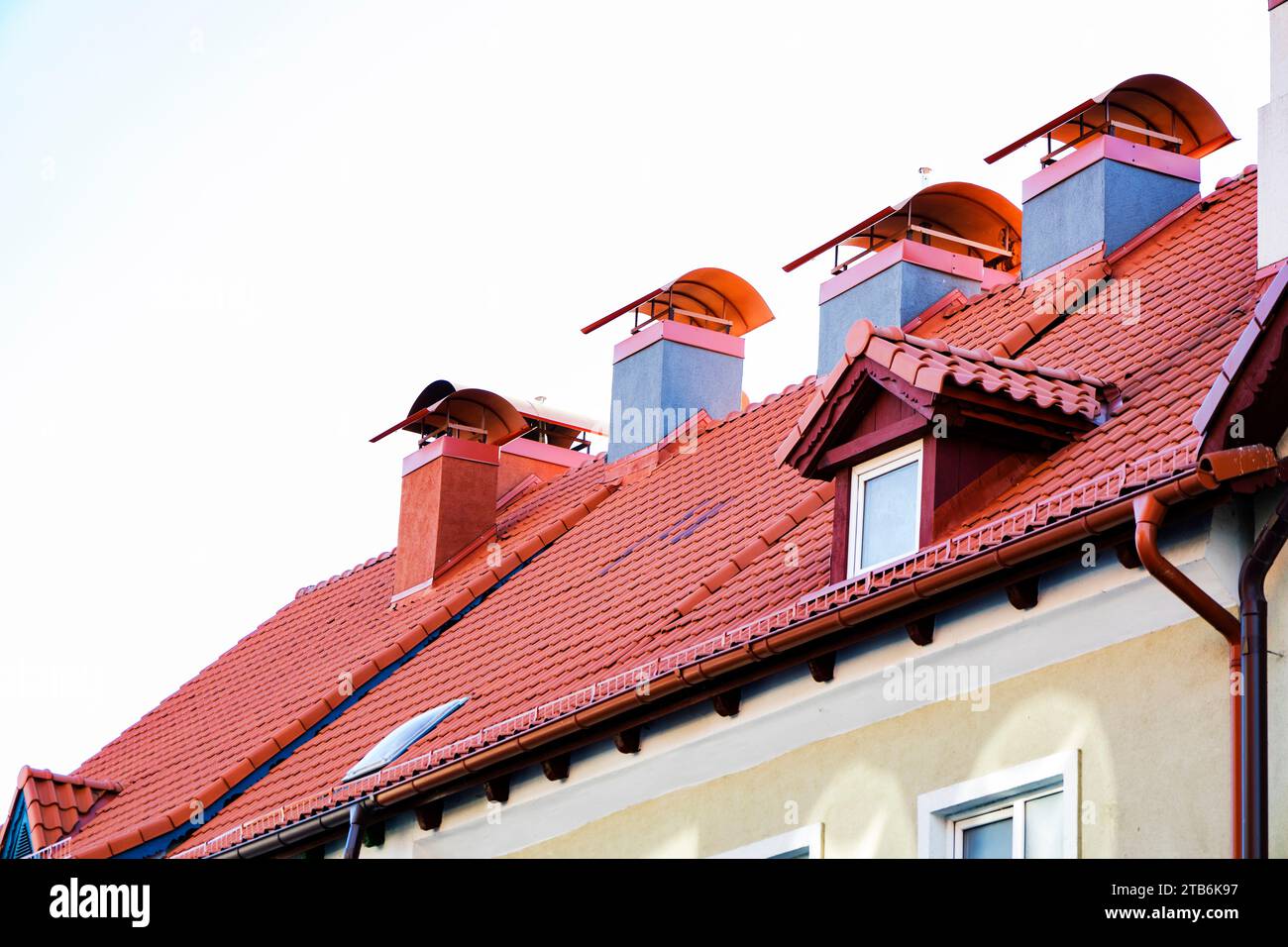 Le toit d'un immeuble résidentiel, avec un toit en tuiles, une cheminée ...