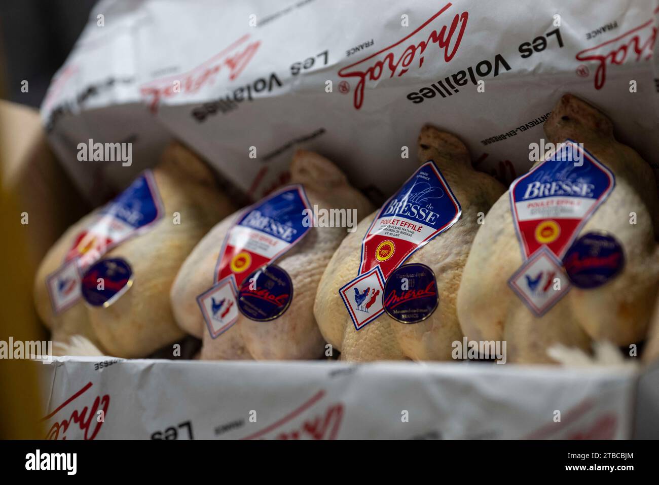 Cette photographie montre un employé qui travaille avec de la volaille ...