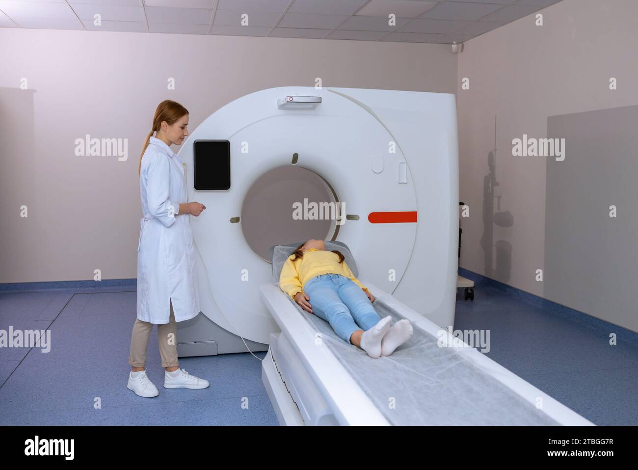 Petite fille allongée sur la table de l'appareil irm pendant que la ...
