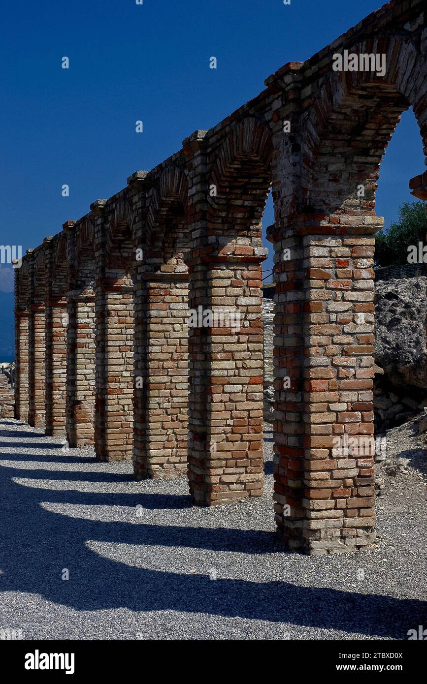 Arcade de briques sous un ciel bleu d'été, au milieu des ruines de la ...
