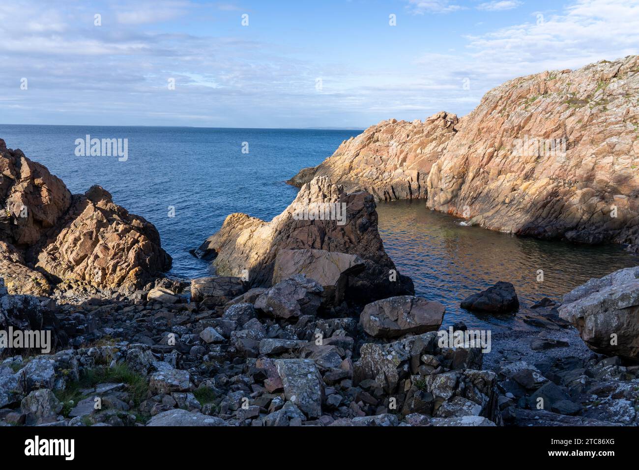 Un paysage côtier pittoresque avec un terrain rocheux et une végétation ...