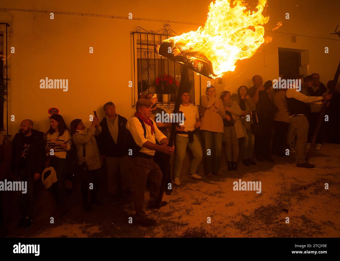Un villageois est vu tenant une torche alors que les gens regardent la ...