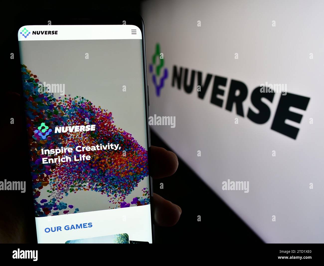Personne détenant un téléphone portable avec le site Web de la société de jeux vidéo Nuverse ...