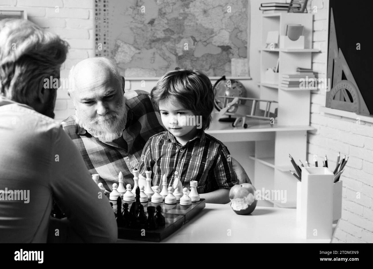 Fête des pères. Grand-père père père et fils jouant aux échecs ...