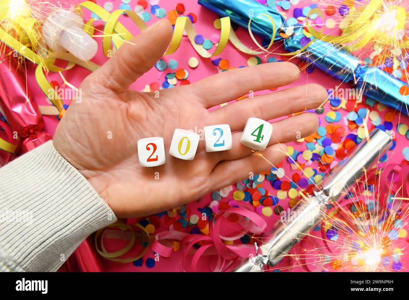 Dés avec l'année 2024 sont d'une part entourés de confettis, guirlandes ...