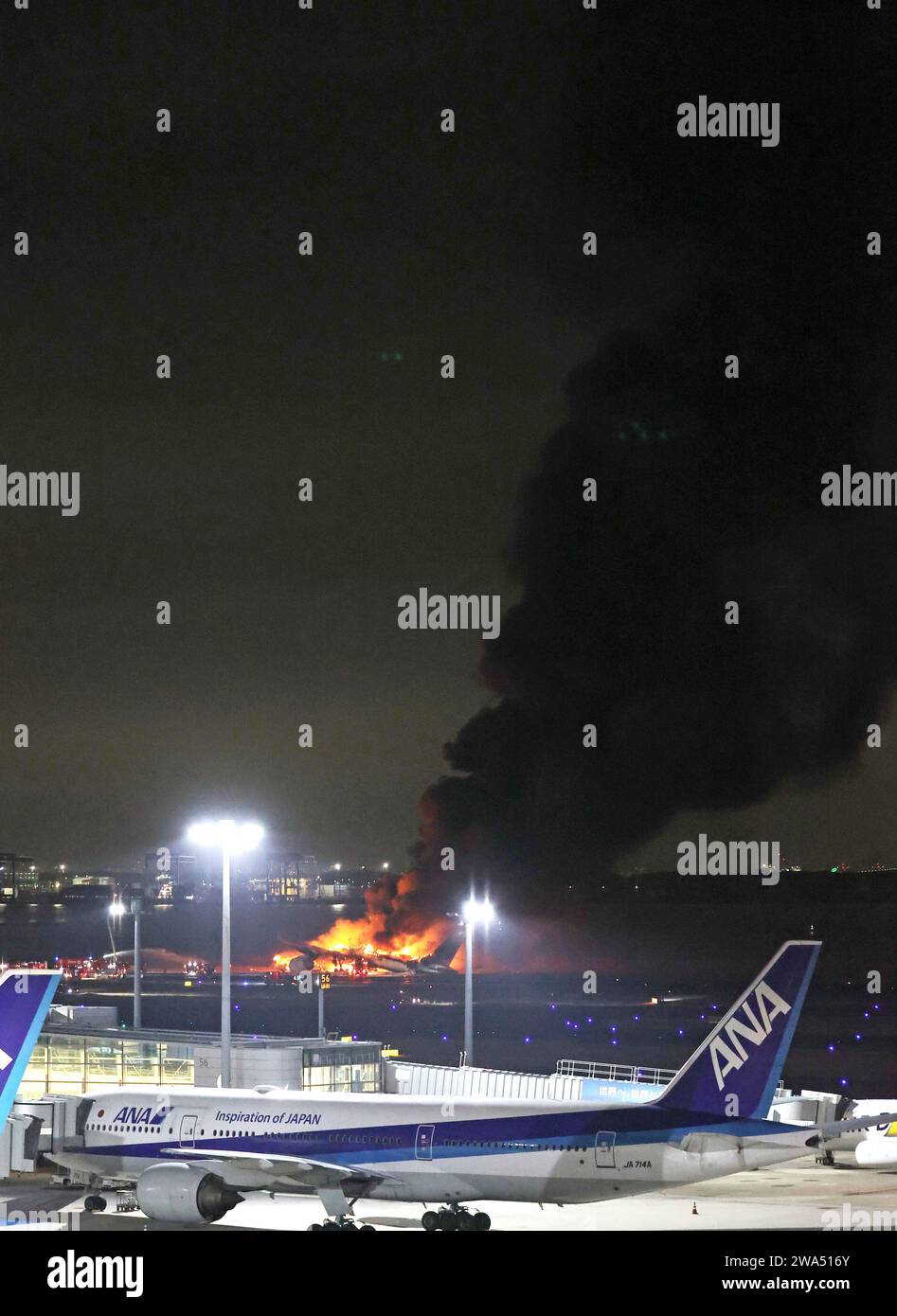 A Japan Airlines plane catches fire on the runway at Haneda Airport in ...