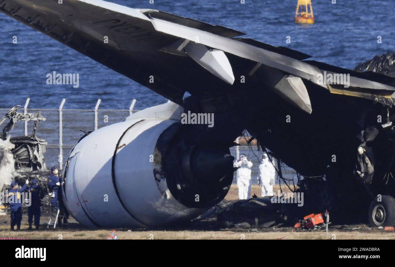 Police investigate the wreckage of Japan Airlines plane at Haneda ...