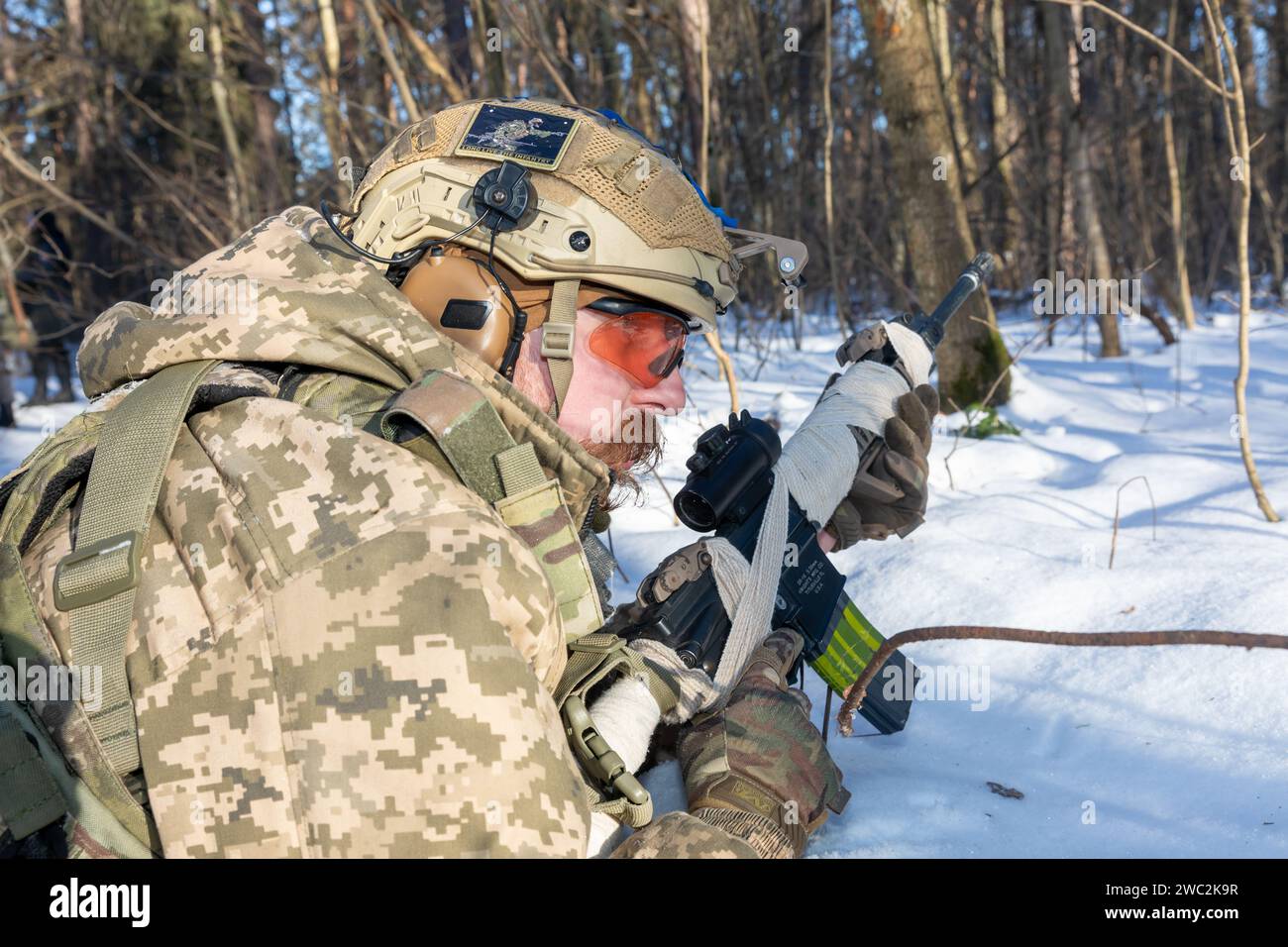 Un civil en uniforme de camouflage avec une arme est vu en position de ...