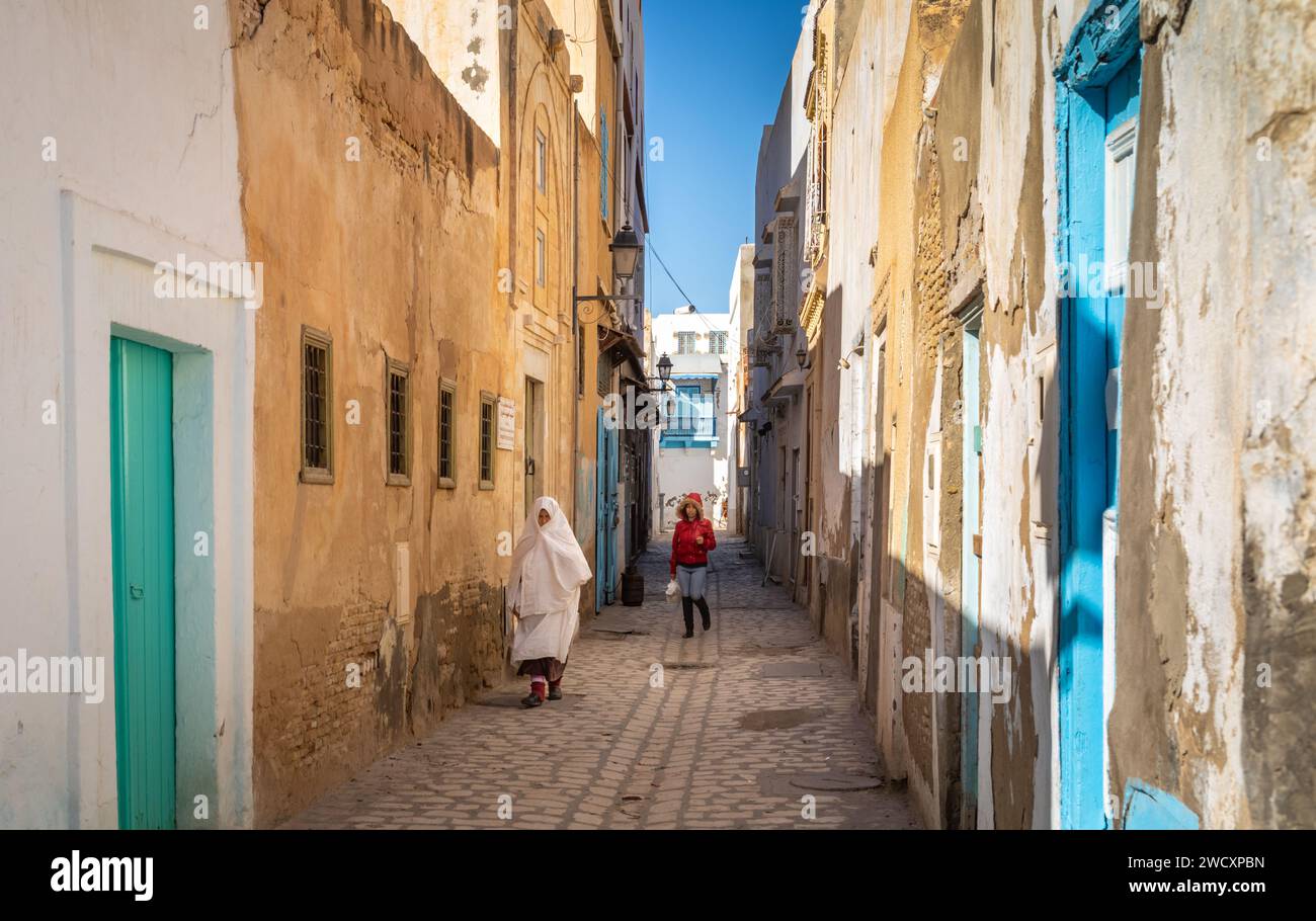 Une femme tunisienne âgée vêtue d'un foutah traditionnel et une jeune ...