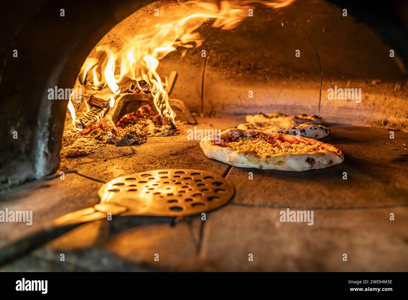 Four traditionnel pour la cuisson de pizza avec bois brûlant et pelle ...