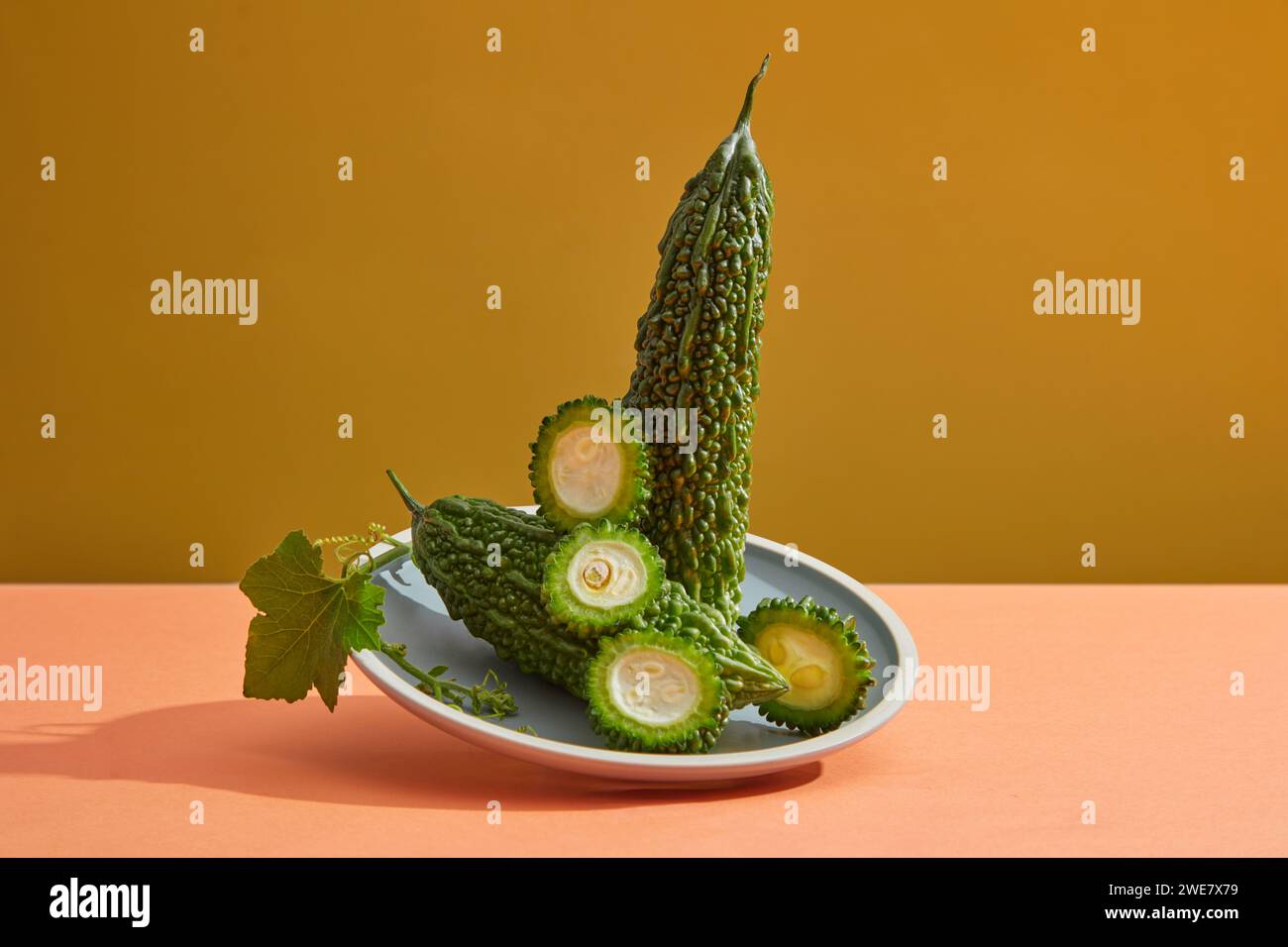 Des tranches rondes fraîches de melon amer sont placées sur un plat ...