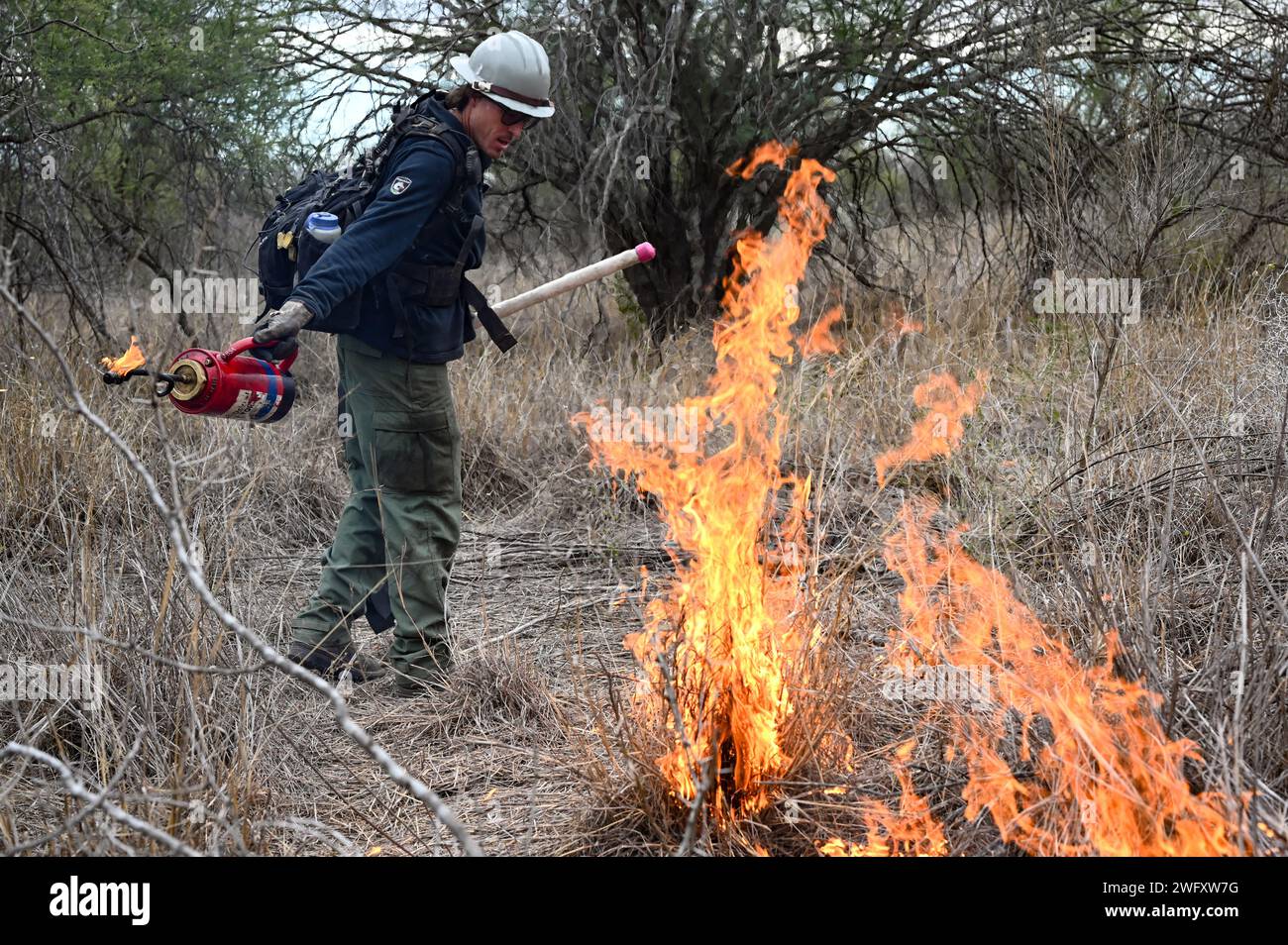 Un pompier de la US Air Force Wildland Fire Branch utilise une torche ...