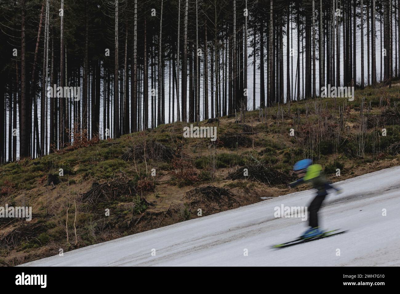 Un skieur skie sur une piste enneigée artificielle et sale, prise sur ...