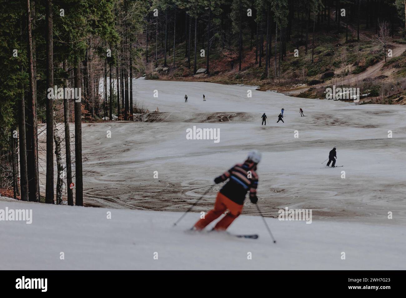 Les skieurs skient sur une piste enneigée et sale, prise sur une piste ...