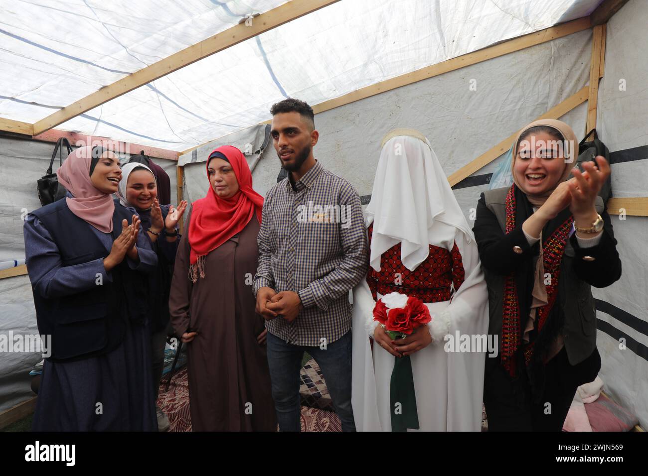 Un marié palestinien, Mahmoud AKhzaiq, et son épouse sont entourés par ...
