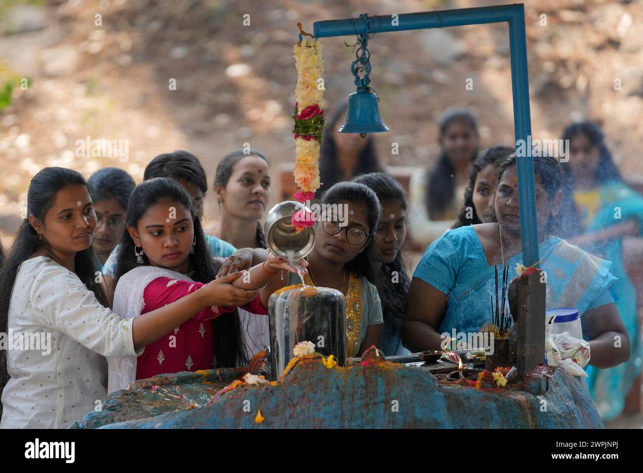 Hindu devotees pour milk on a shivling, a representation of Hindu god ...