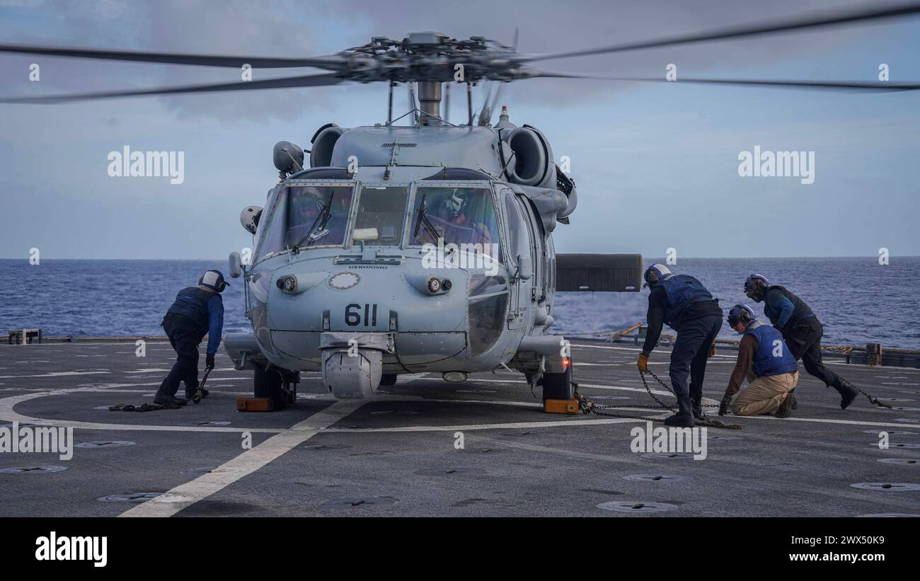 Les marins présentent des cales et des chaînes à un Sea Hawk SH-60S ...