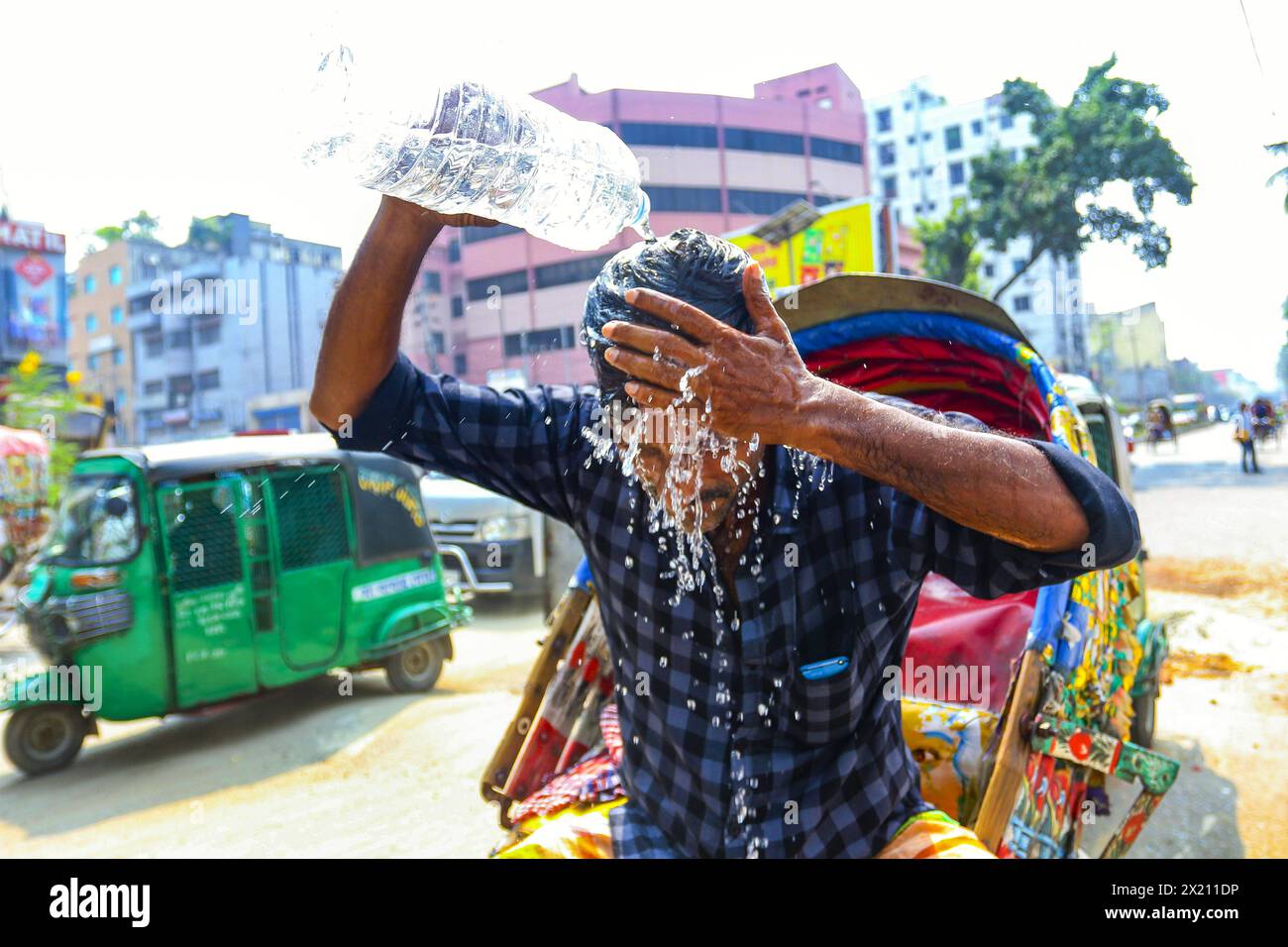 Hitzewelle au Bangladesh, Un chauffeur de pousse-pousse se lave le ...