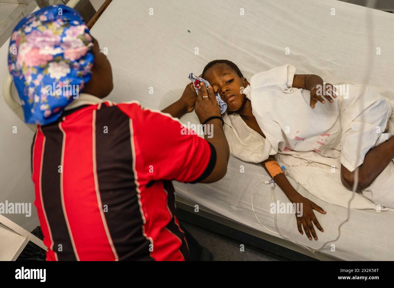 FILE - Denize Flerino wipes sweat from the brow of her son who is ...