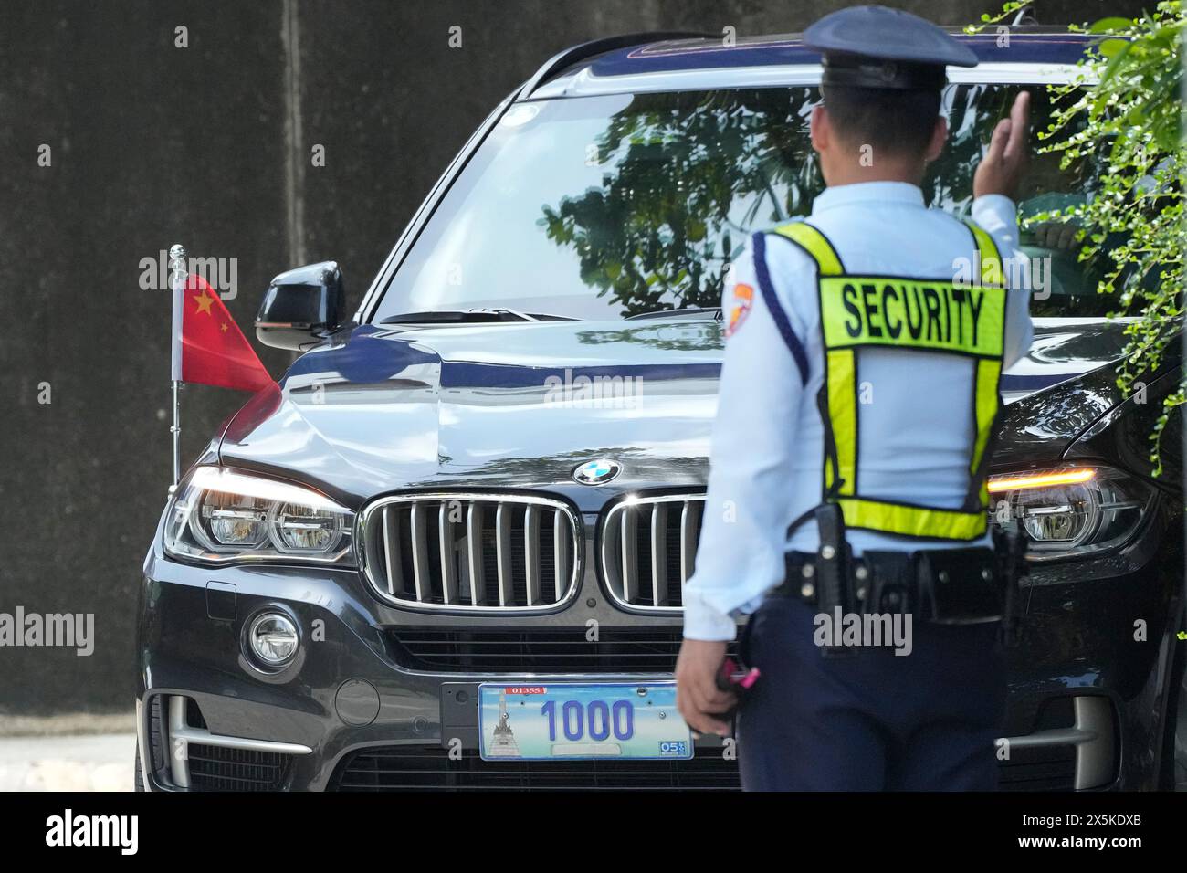 FILE - A security guard signals to a car with diplomatic plates and ...